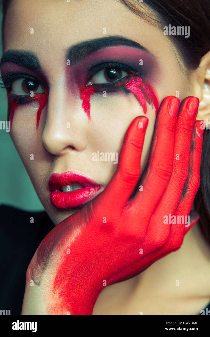 portrait of freak monster with mess dirty colored makeup on her face ...