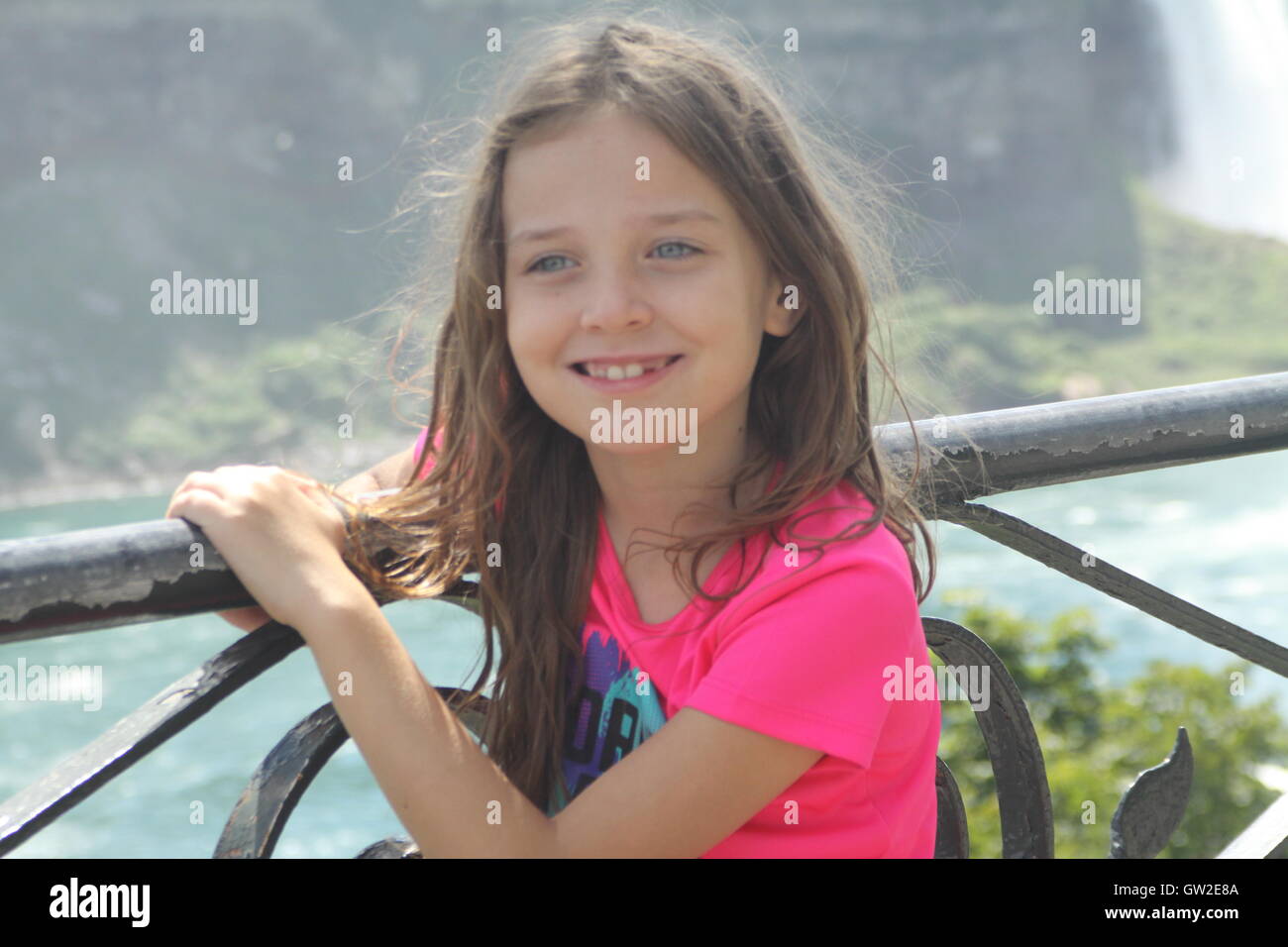 Very pretty girl child in pink, leaning against safety railing Stock ...