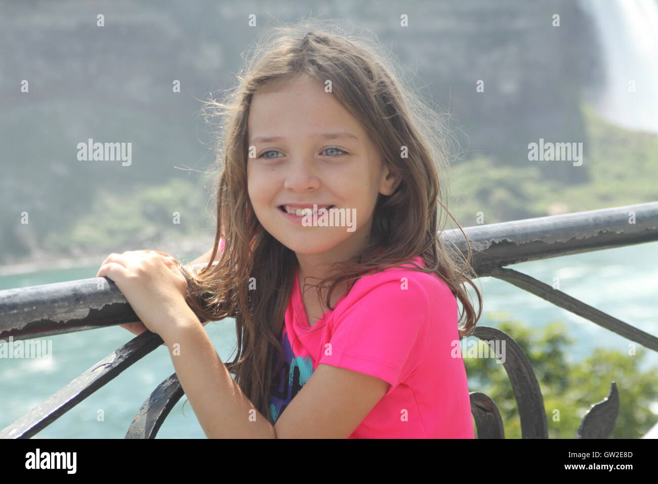Very pretty girl child in pink, leaning against safety railing Stock ...