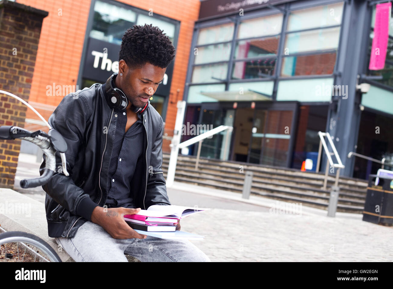 student sitting outside his college reading text books Stock Photo - Alamy