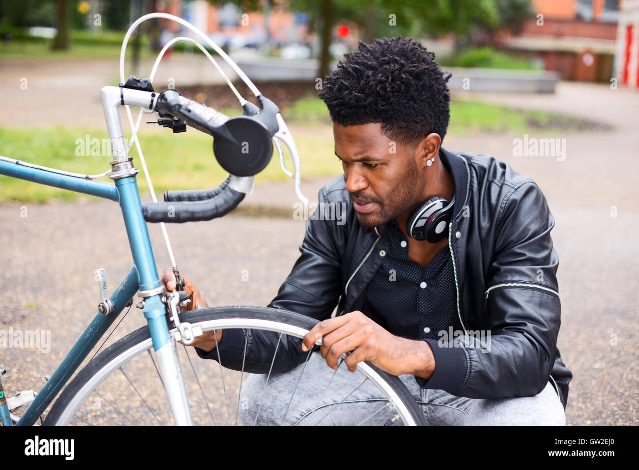 young man checking his bicycle wheel Stock Photo - Alamy
