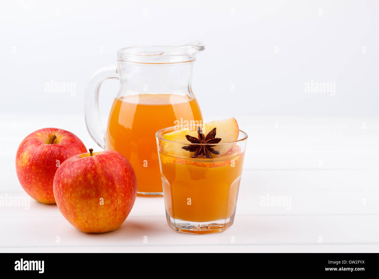 Fresh apple juice and ripe fruits arranged on white wooden table Stock ...