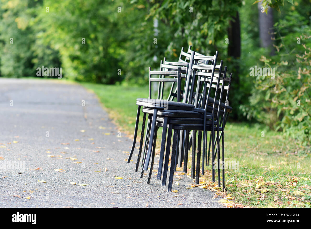 Metal chairs stacked on the side of the road Stock Photo - Alamy