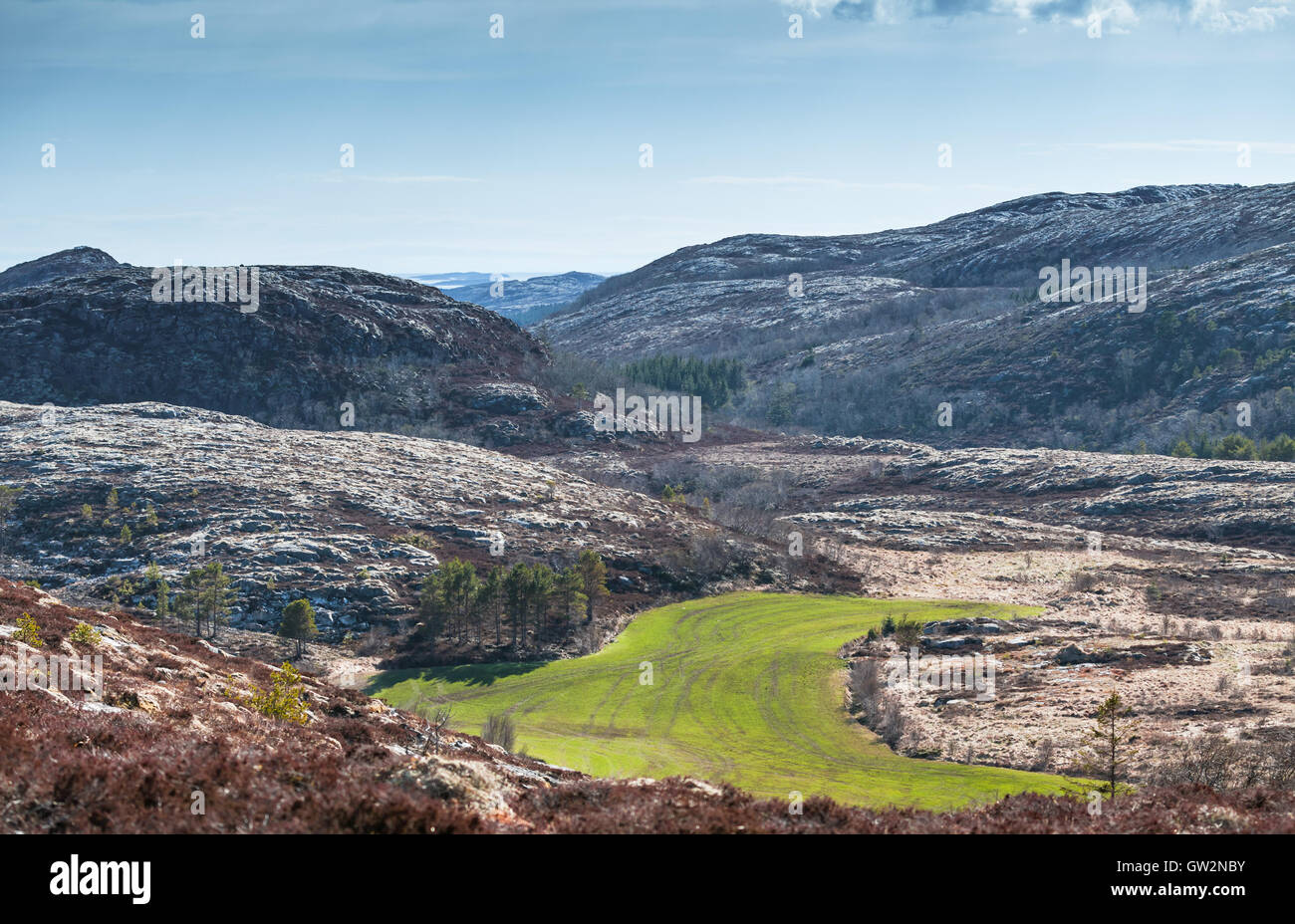 Norwegian spring landscape with rocky mountains and green field under ...