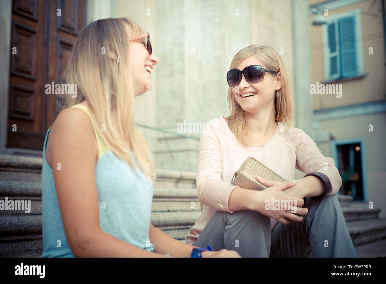 two beautiful blonde women talking Stock Photo - Alamy
