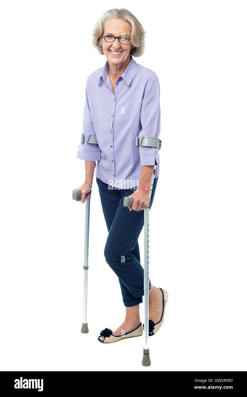 Bespectacled old woman walking with crutches Stock Photo - Alamy