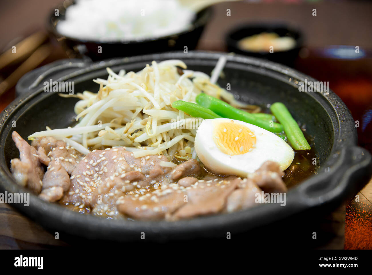 Korean spicy bbq pork served on a hot plate with side dishes and rice ...