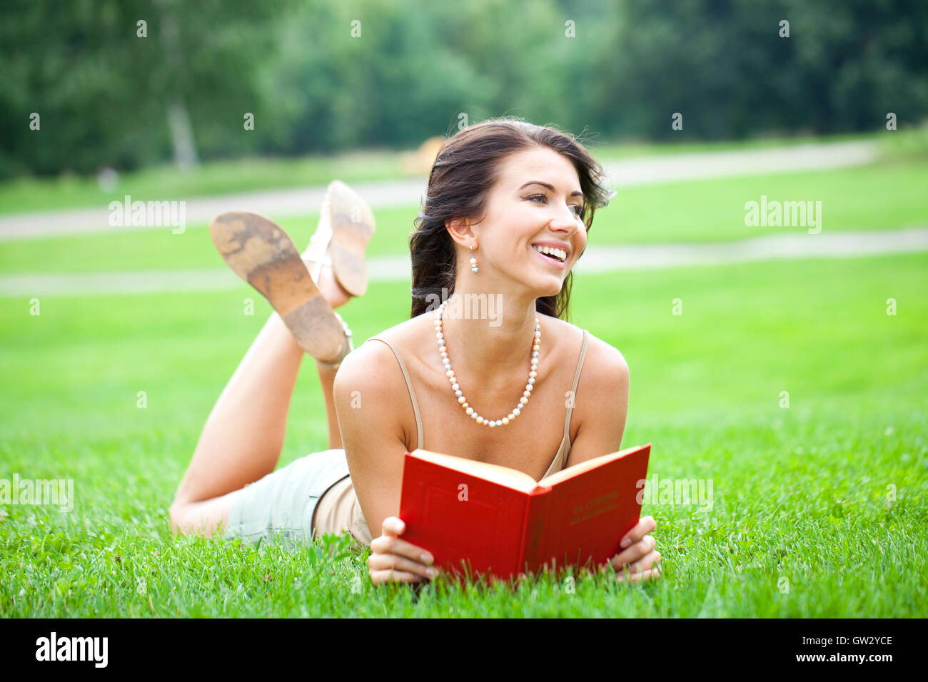 Young beautiful young woman reading a book outdoor Stock Photo - Alamy