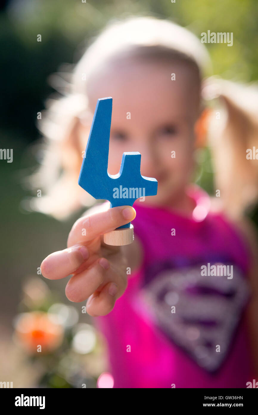 Child holding blue number four Stock Photo - Alamy