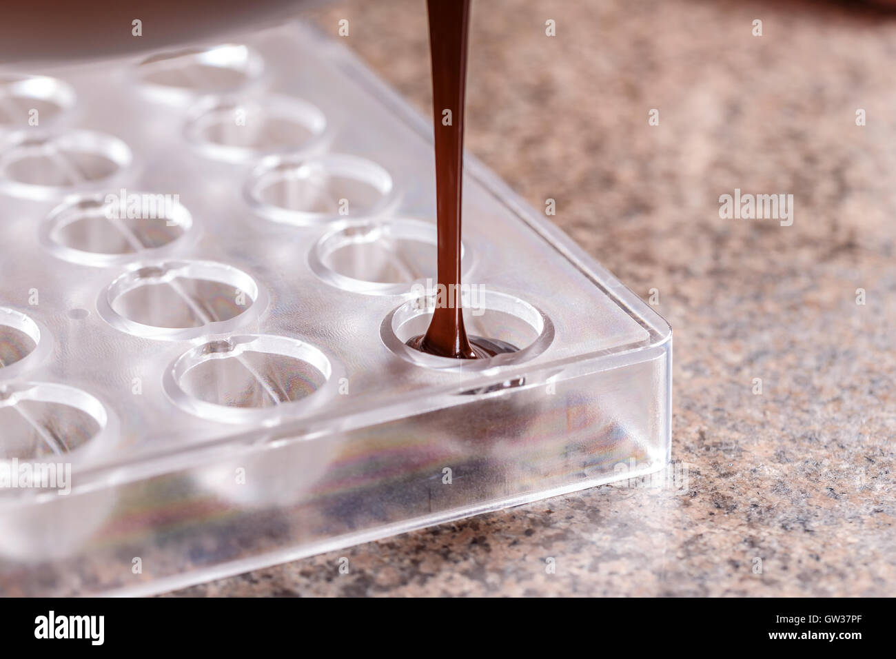 Pour liquid chocolate in forms Stock Photo - Alamy