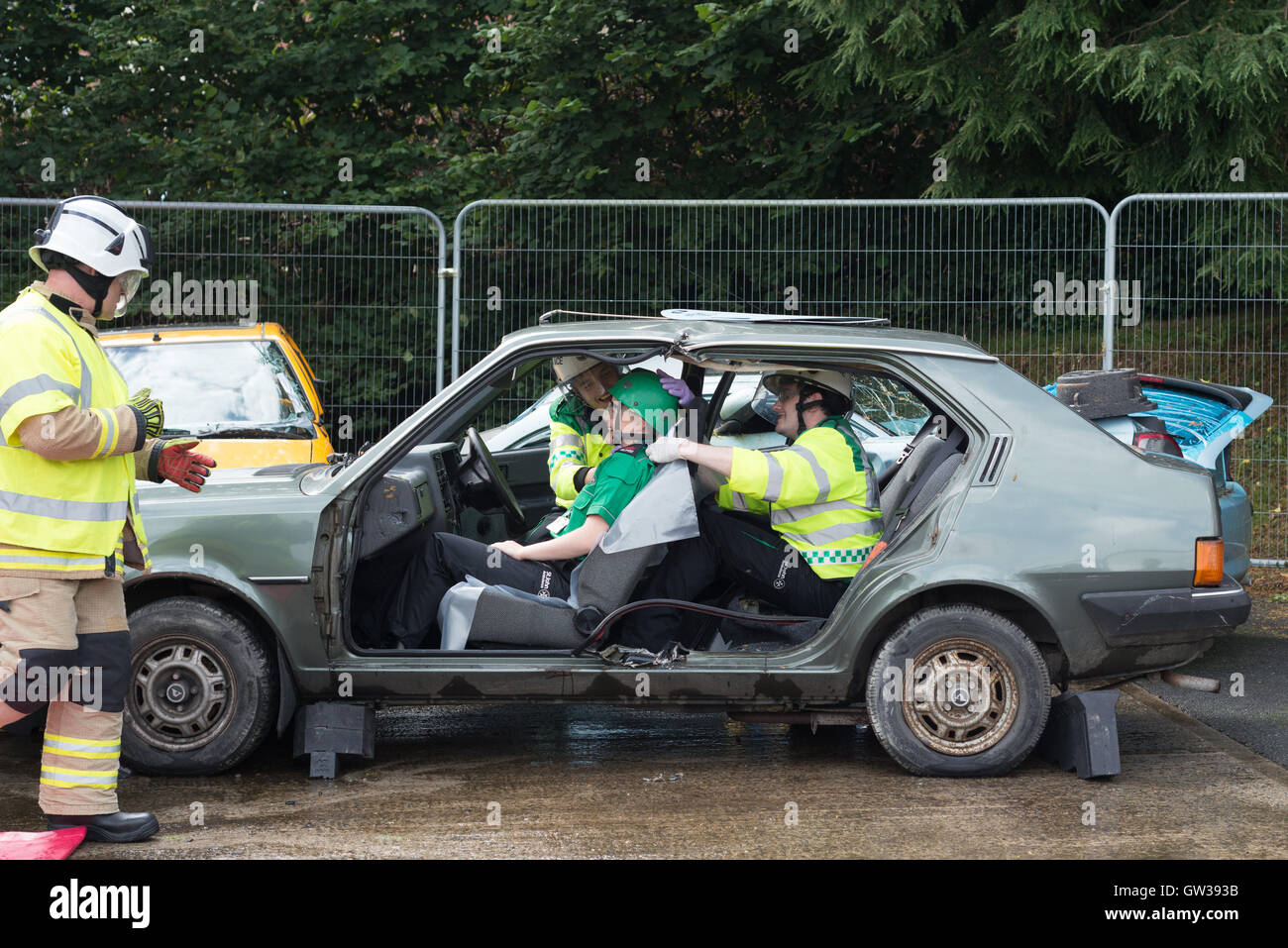 Fire men simulate a car crash rescue by cutting the doors off the car ...