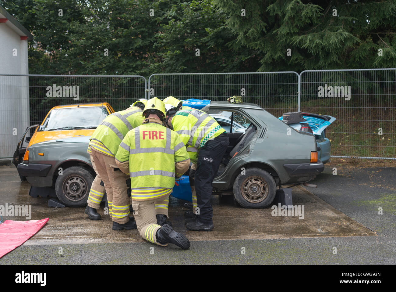 Fire men simulate a car crash rescue by cutting the doors off the car ...