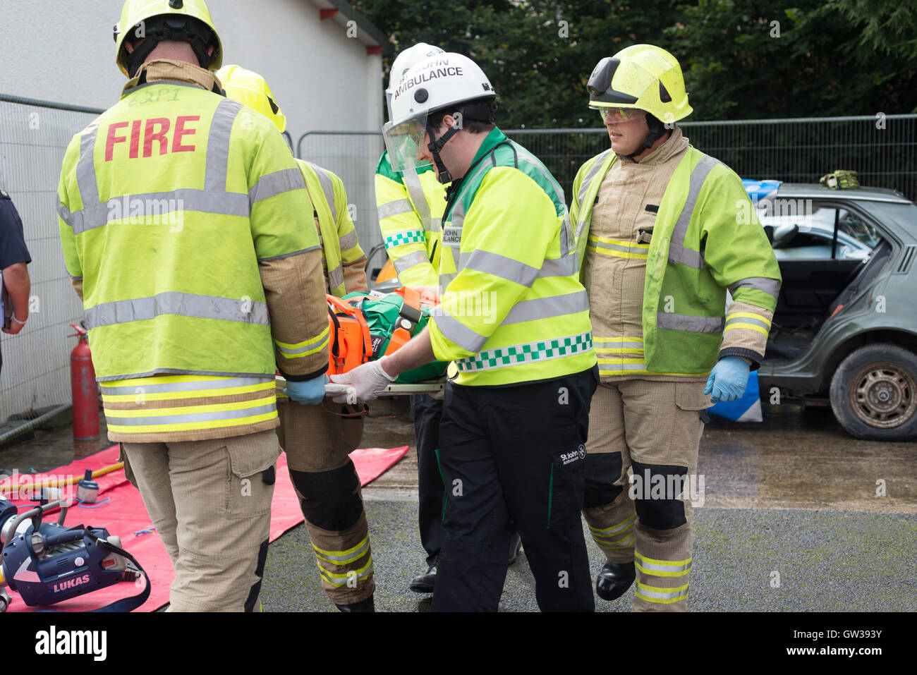 Fire men simulate a car crash rescue by cutting the doors off the car ...