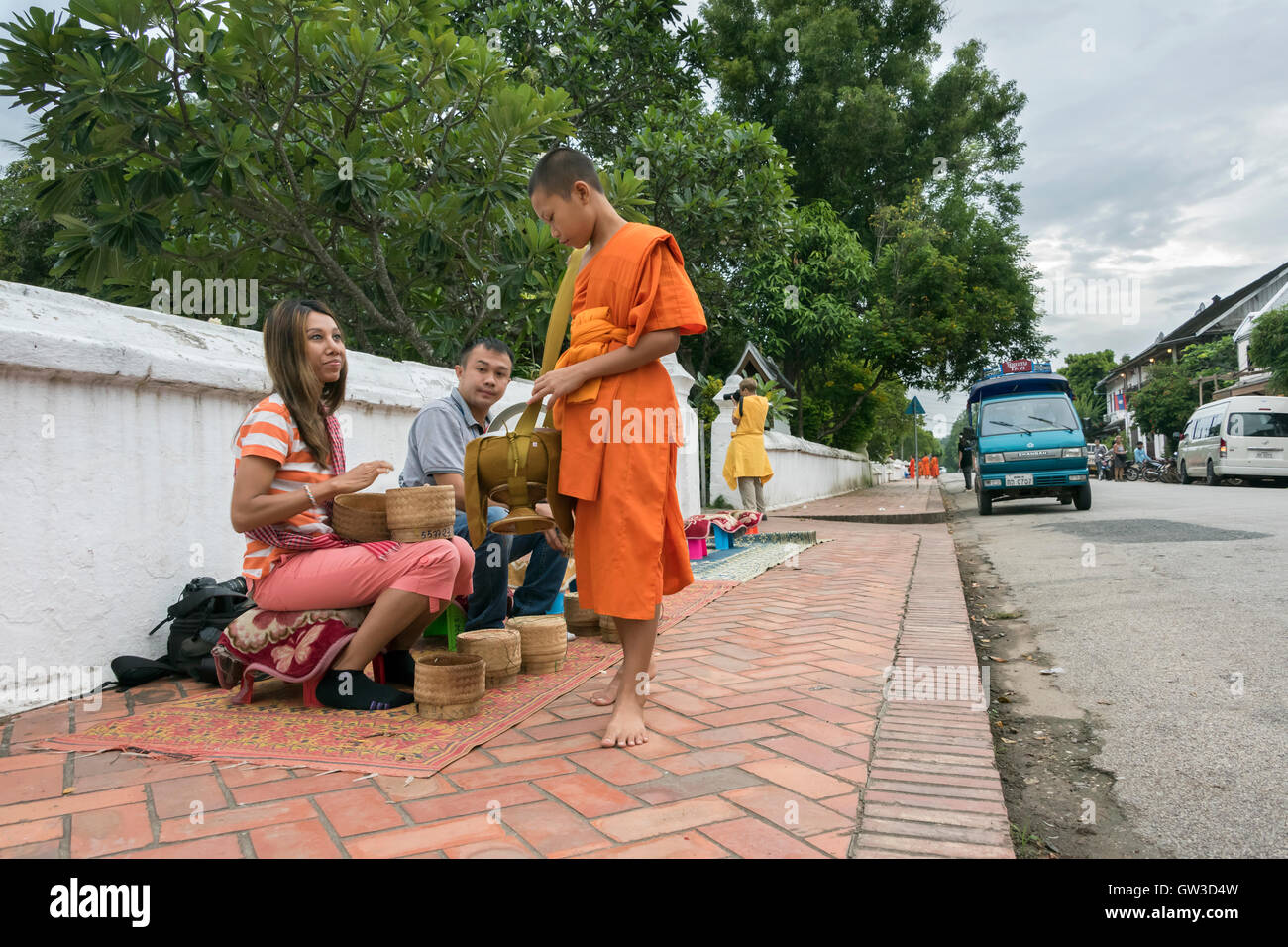 Giving alms to a Buddhist monk, Sisavang Vong Road, Luang Prabang, Laos ...
