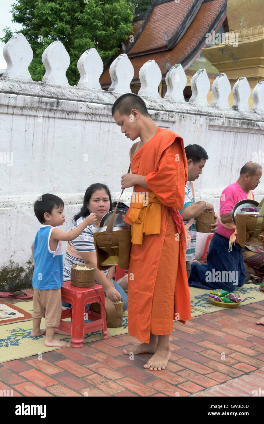 The monk and the small boy, alms giving ceremony, Luang Prabang, Laos ...