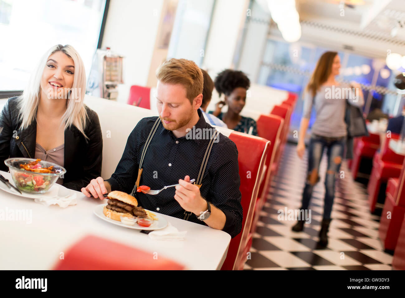 Friends eating fast food at the table in the diner Stock Photo - Alamy