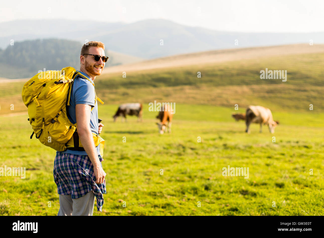 View of happy young man hiking in countryside Stock Photo - Alamy