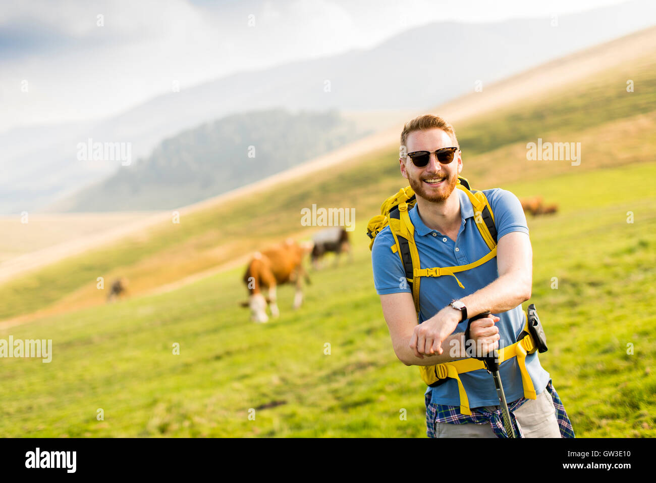 View of happy young man hiking in countryside Stock Photo - Alamy