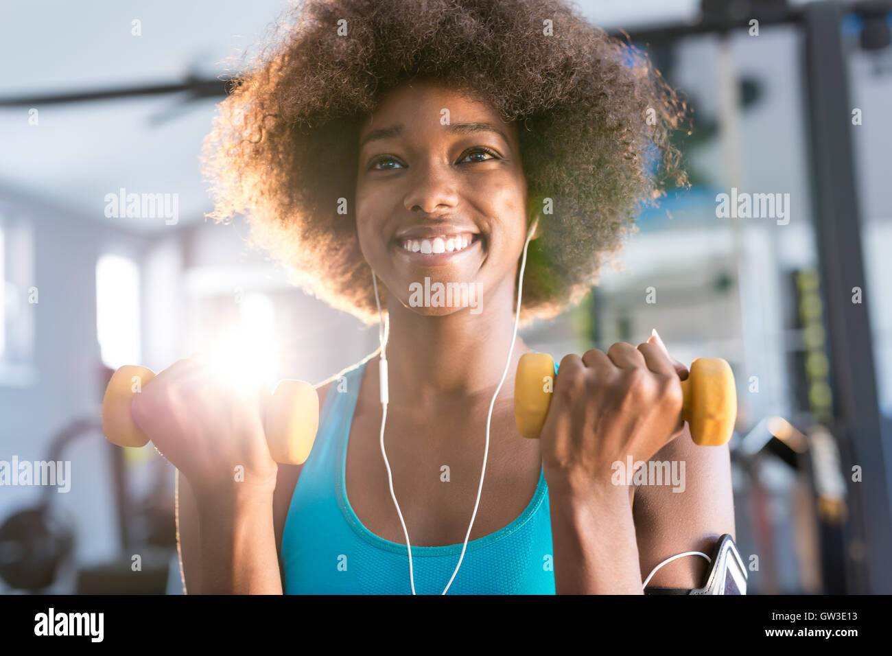 Happy healthy young African American woman working out in a gym with a ...