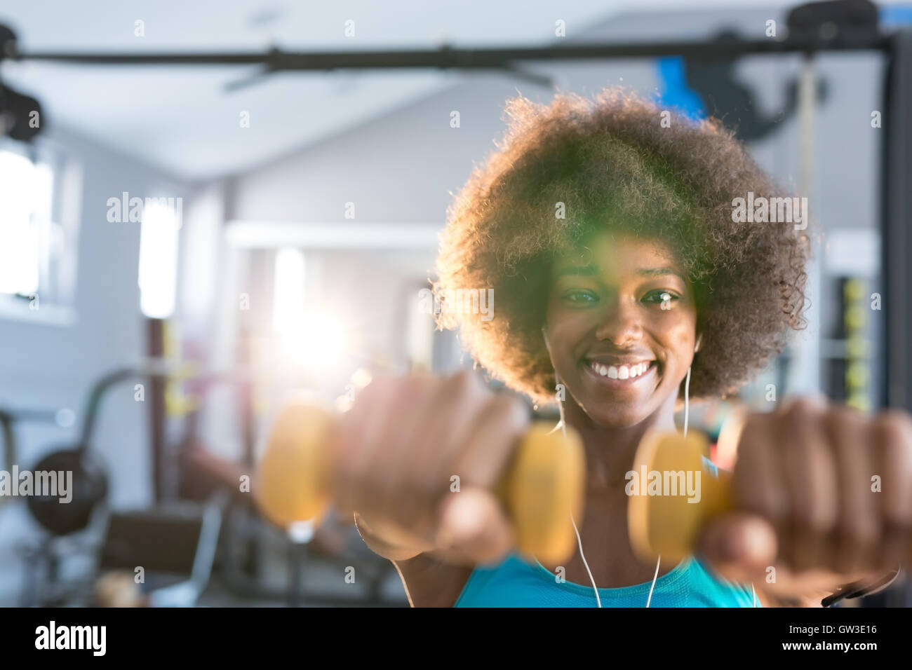 Happy healthy young African American woman working out in a gym with a ...