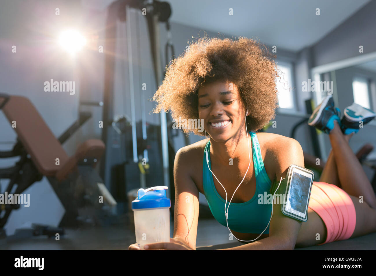 Young african female in a gym in front of gym equipment Stock Photo - Alamy