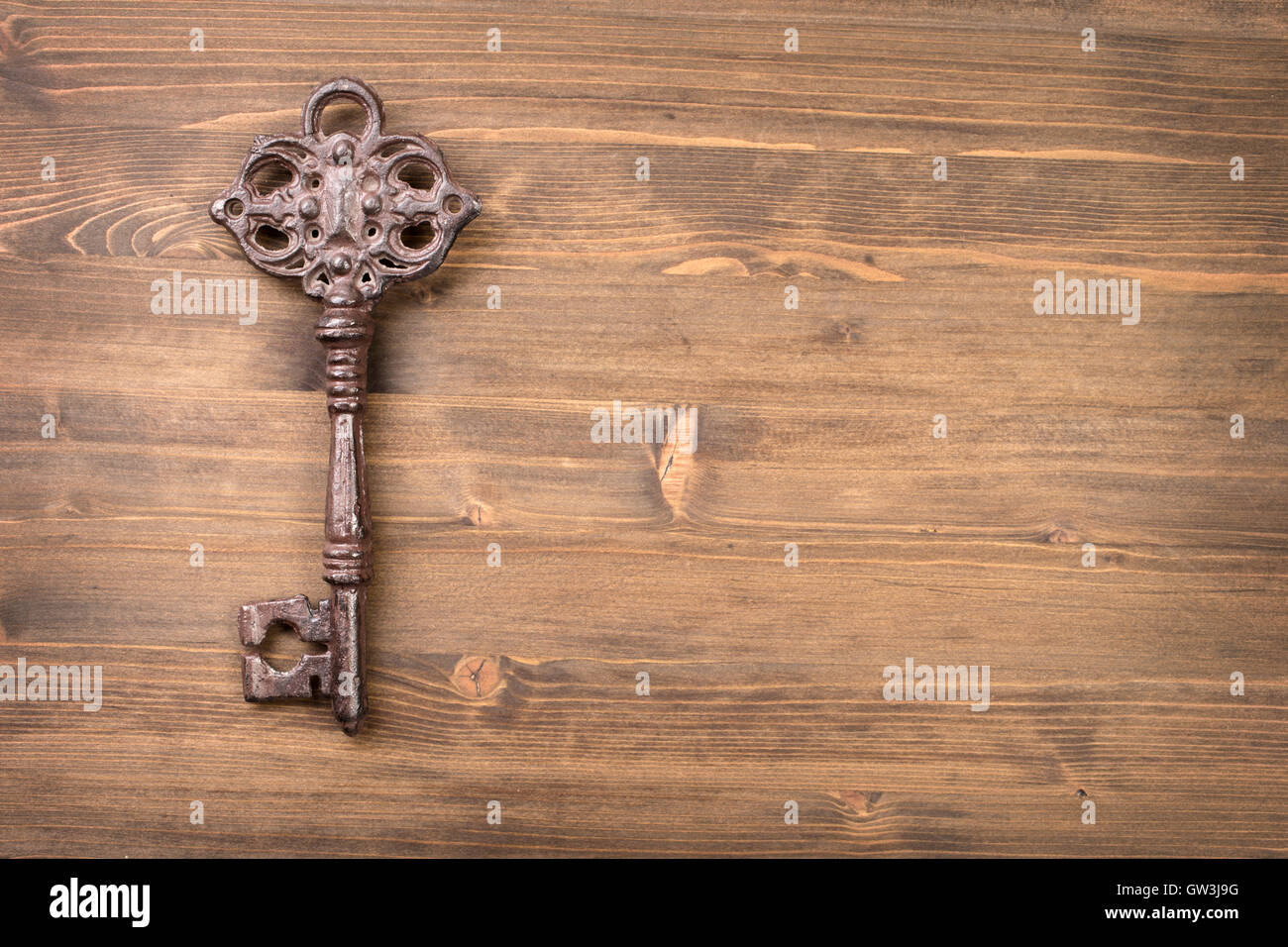 Old vintage key from left side of wooden background Stock Photo - Alamy