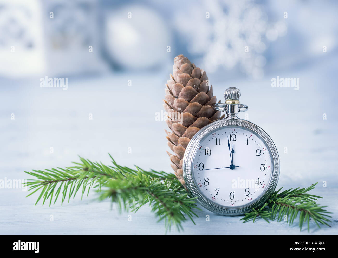 Pocket watch and fir tree branch on blue background Stock Photo - Alamy