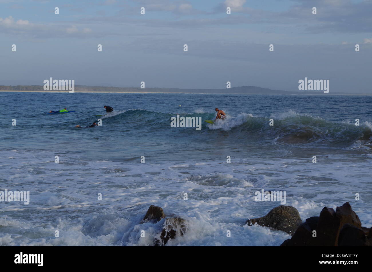 Surfer catching a wave Stock Photo - Alamy
