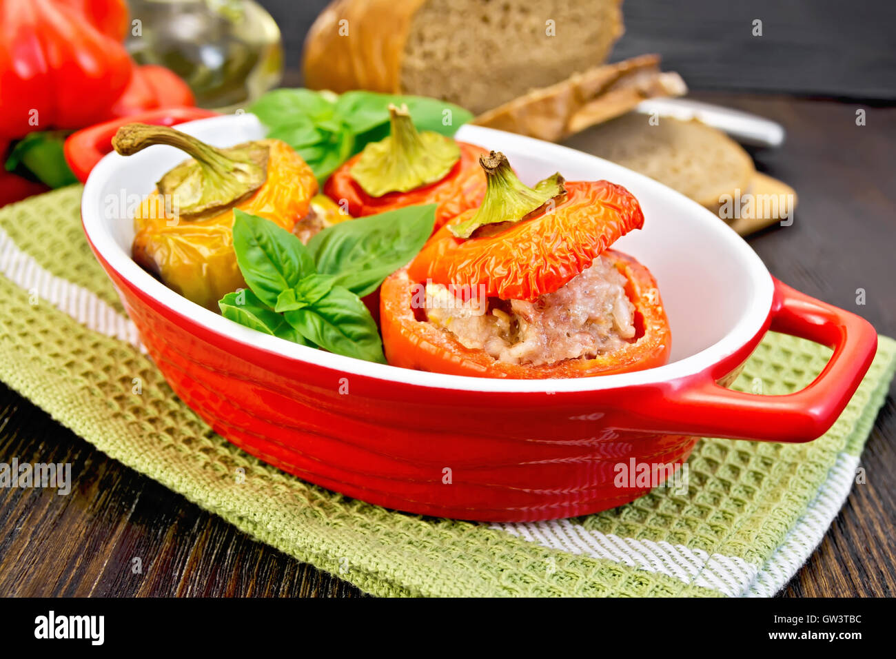 Pepper stuffed meat in red roaster on dark board Stock Photo - Alamy