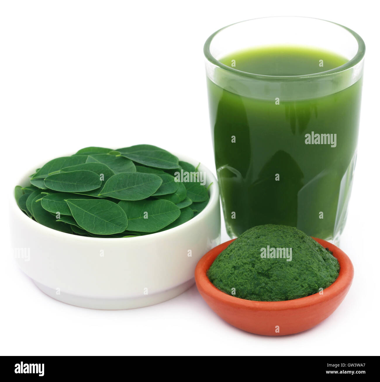 Edible moringa leaves with extract and ground paste over white ...