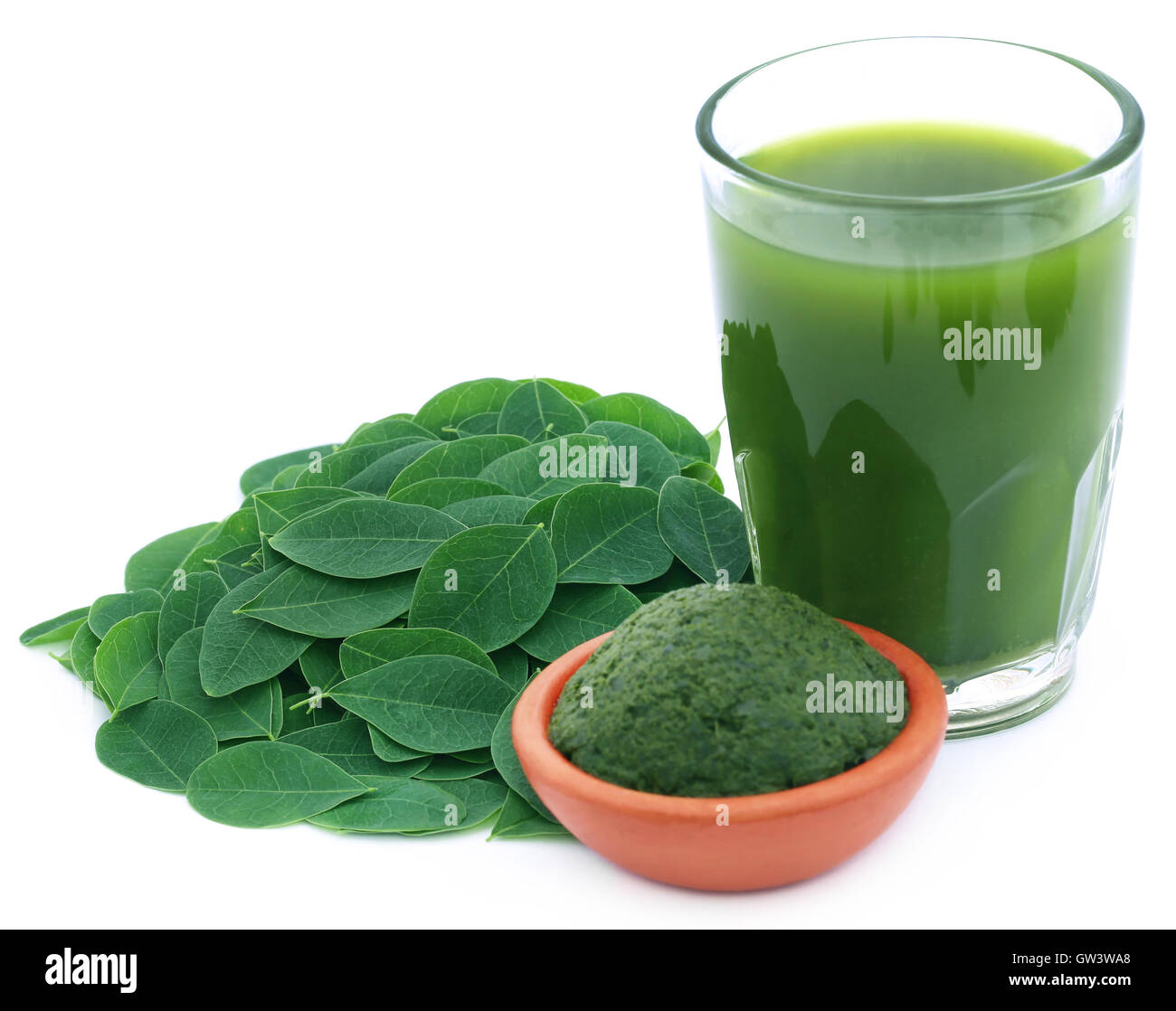 Edible moringa leaves with extract and ground paste over white ...