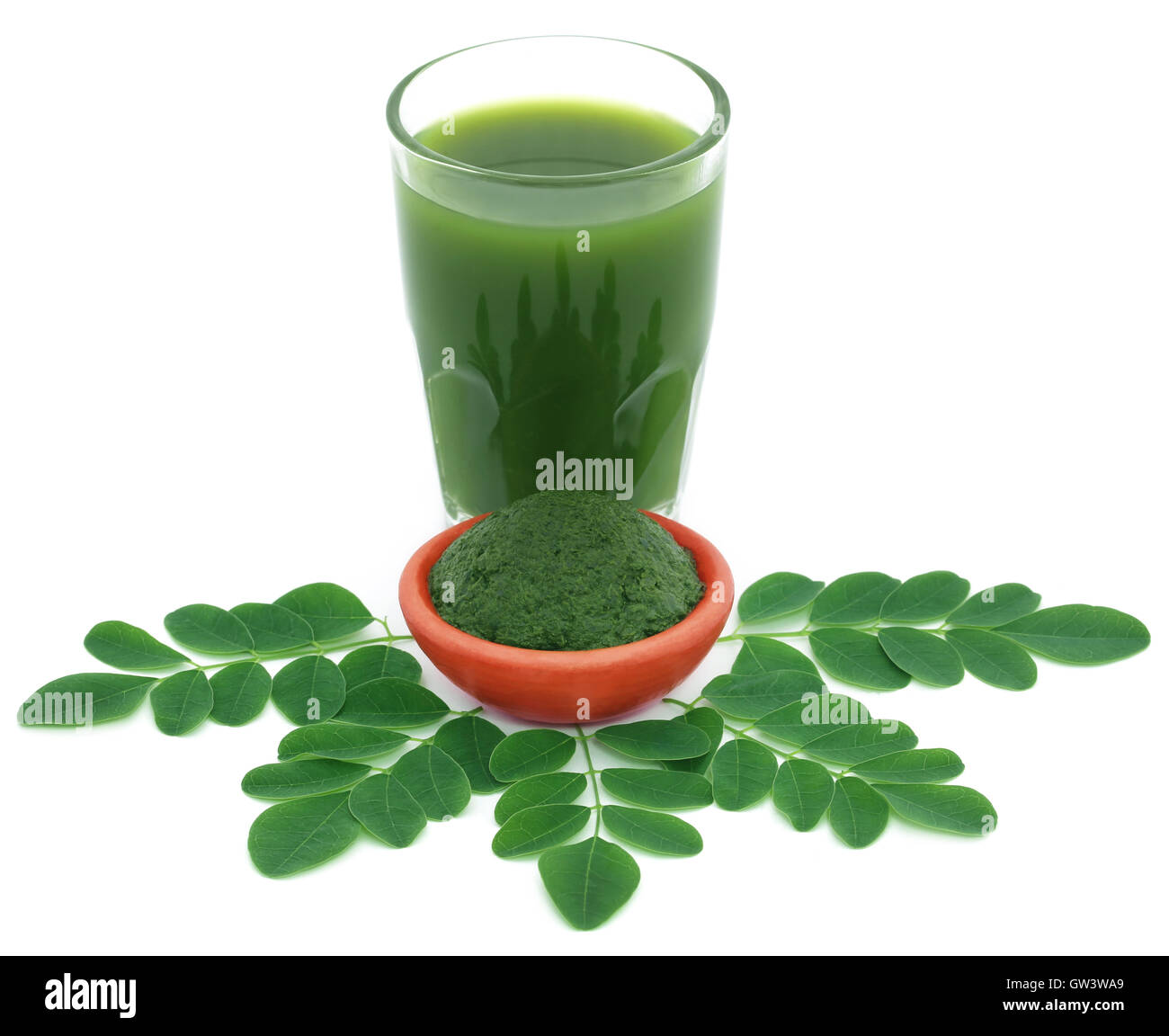 Edible moringa leaves with ground paste over white background Stock ...