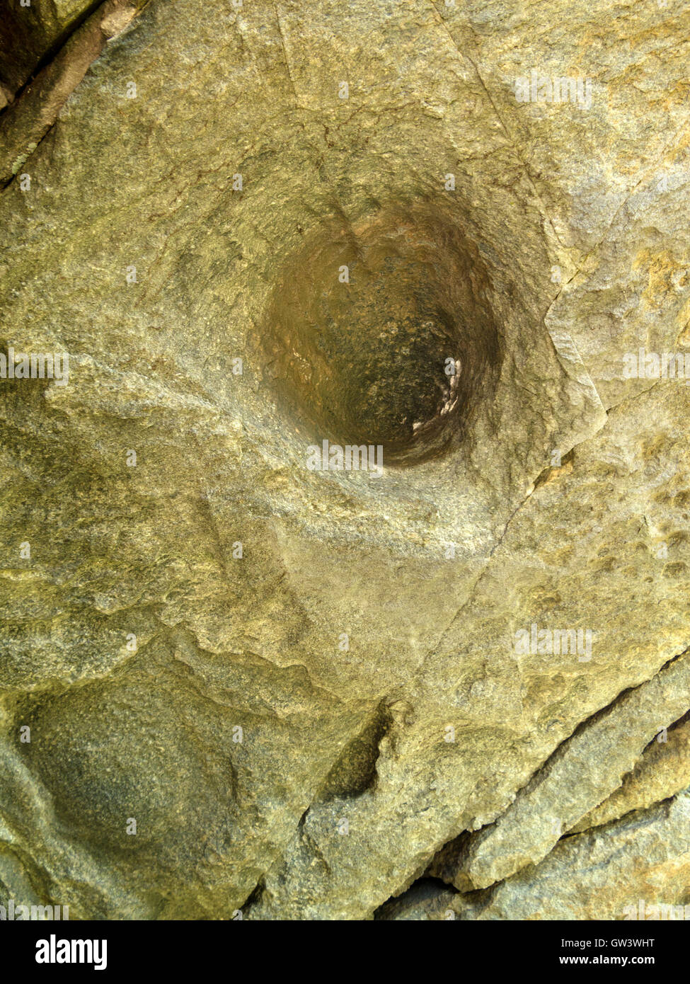 Ancient cup mark in rock by cave entrance, Port nam Fliuchan, Uragaig ...