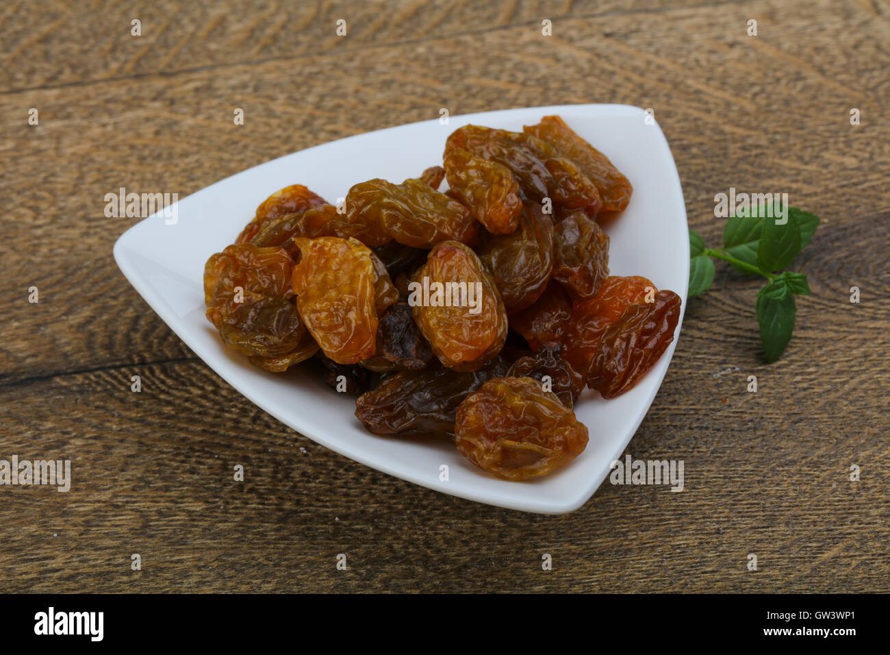 Sweet raisins in the bowl with mint leaves Stock Photo - Alamy