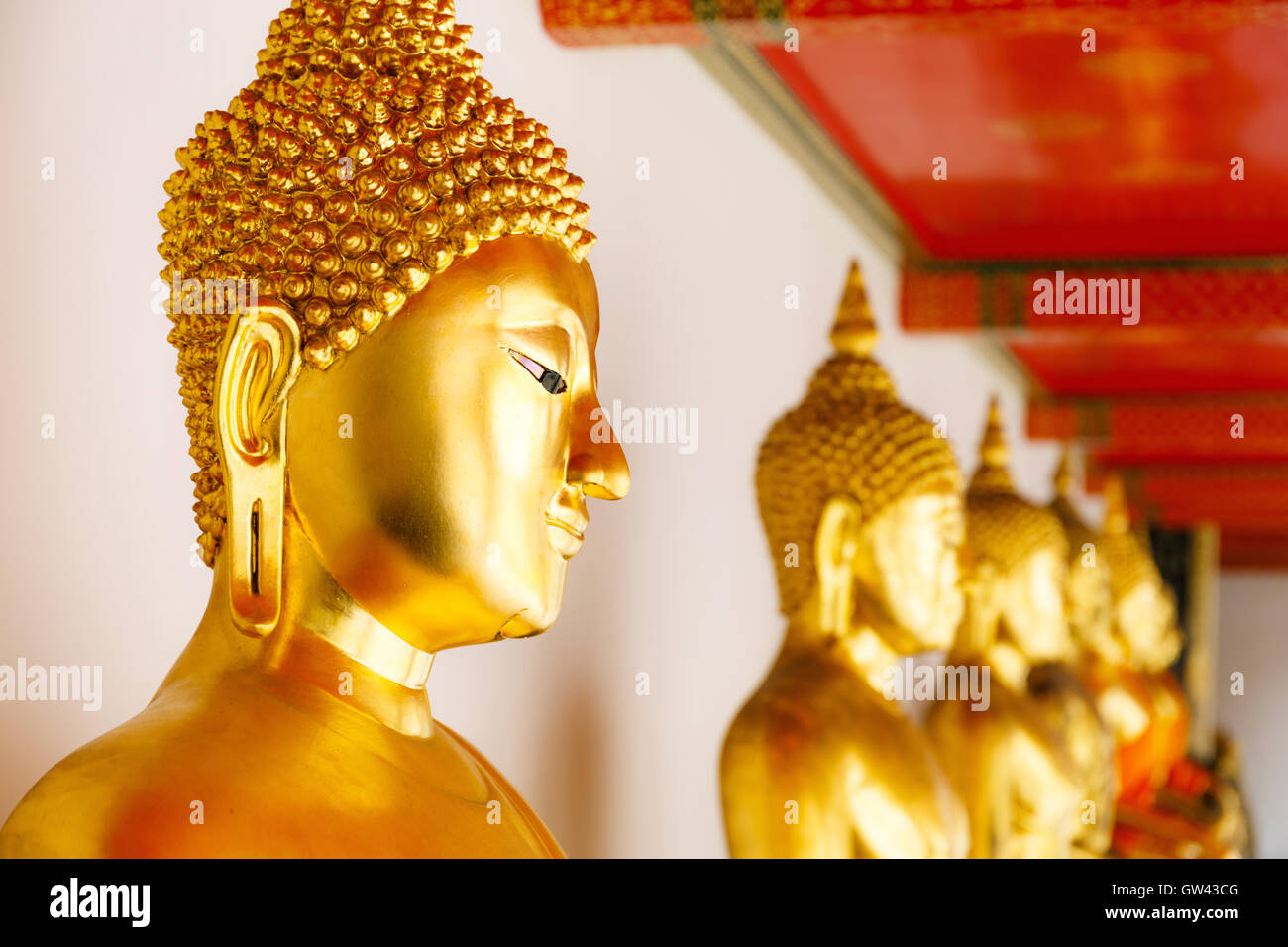 Golden Buddha in a row Stock Photo - Alamy
