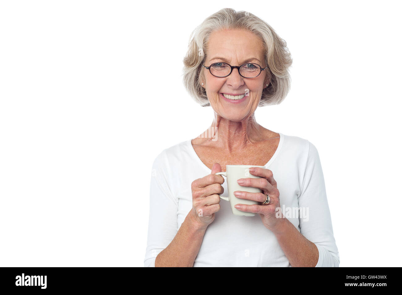 Smiling bespectacled old lady drinking coffee Stock Photo - Alamy