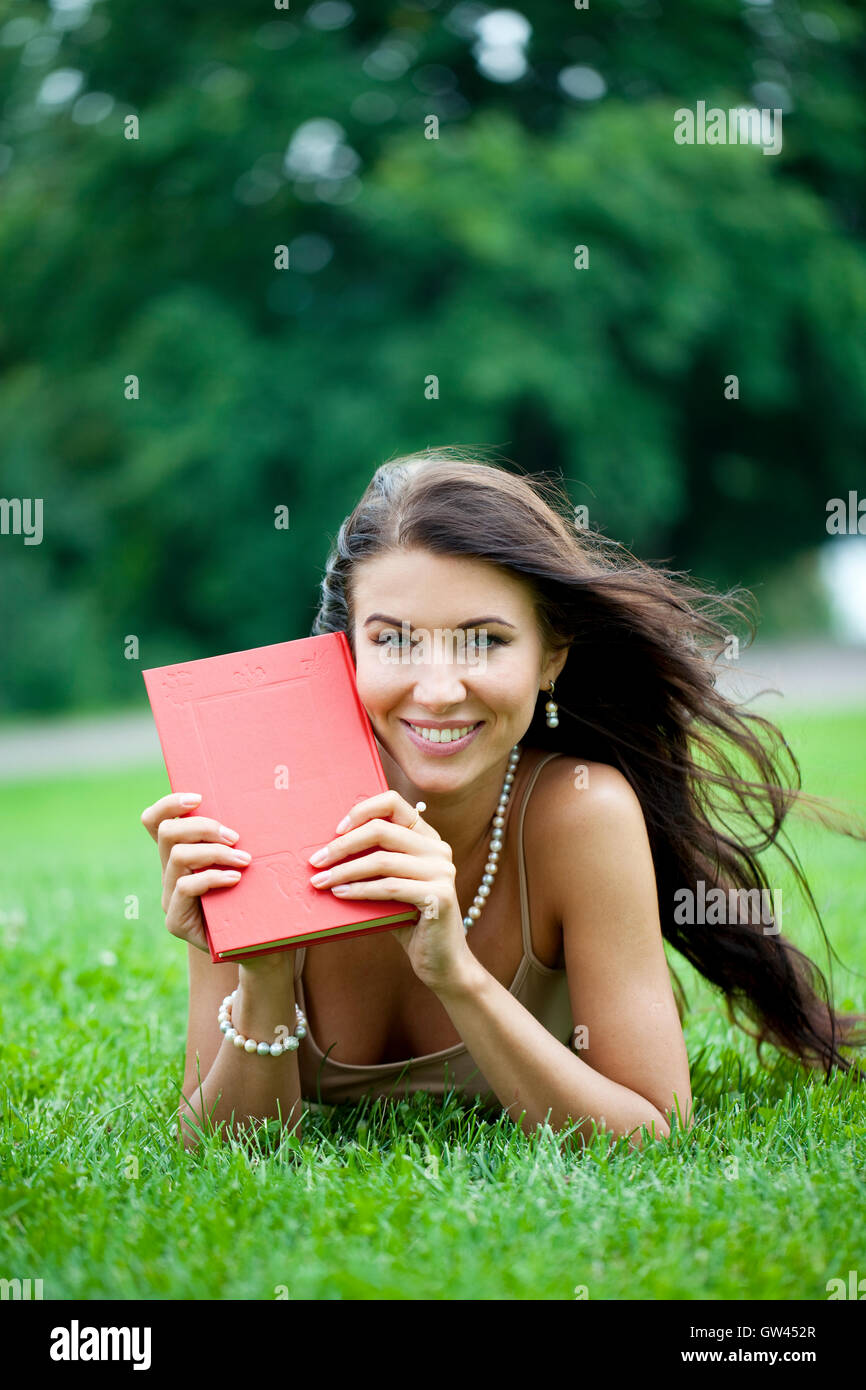 Young beautiful young woman reading a book outdoor Stock Photo - Alamy