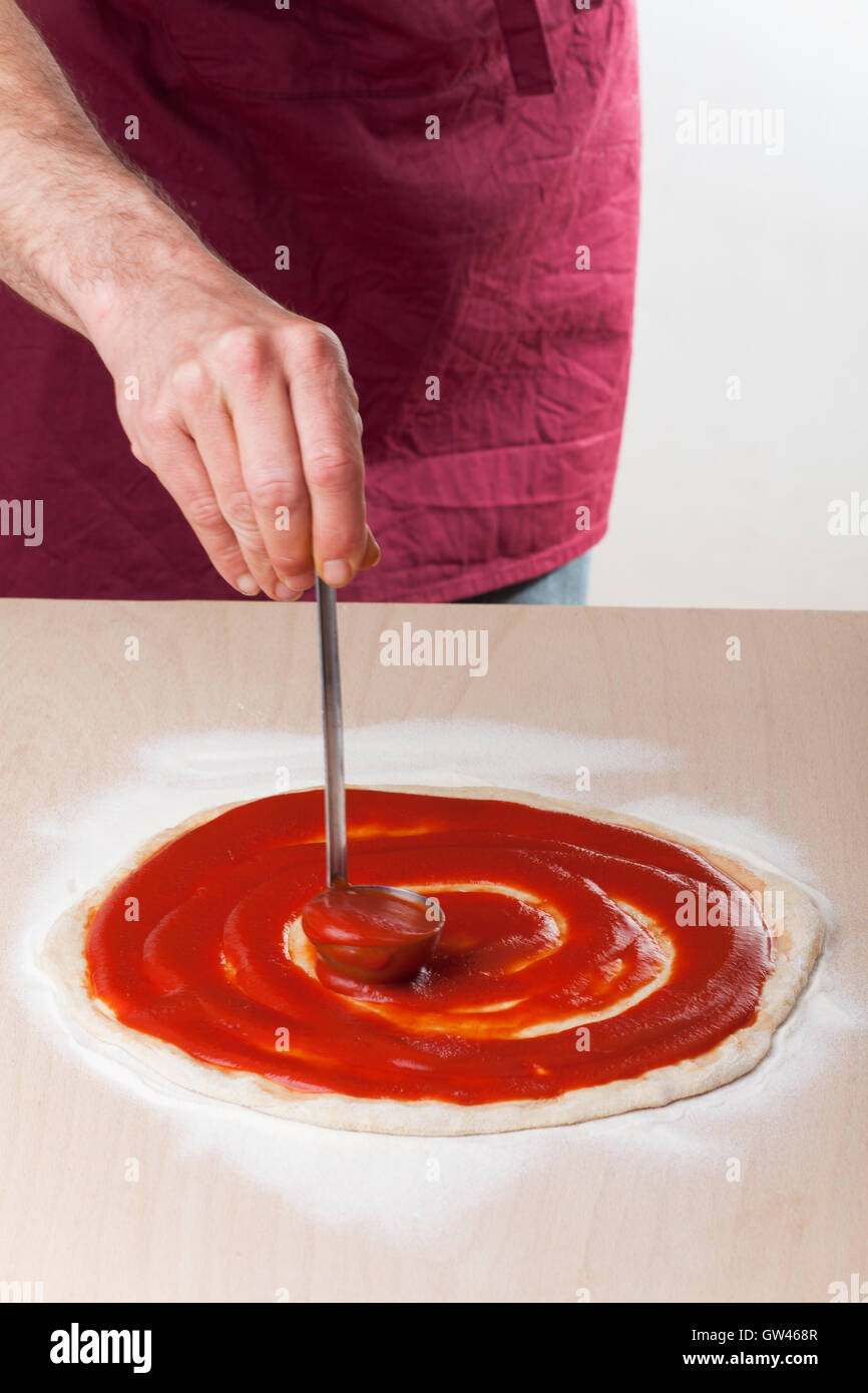 pouring tomato sauce on a pizza Stock Photo - Alamy