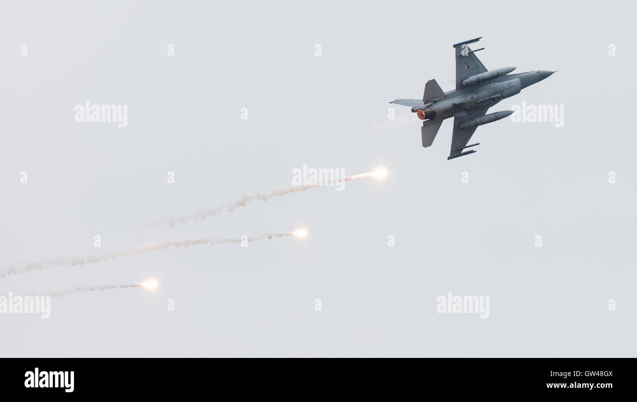 LEEUWARDEN, THE NETHERLANDS - JUN 11, 2016: Dutch F-16 fighter jet firing off flares during a ...