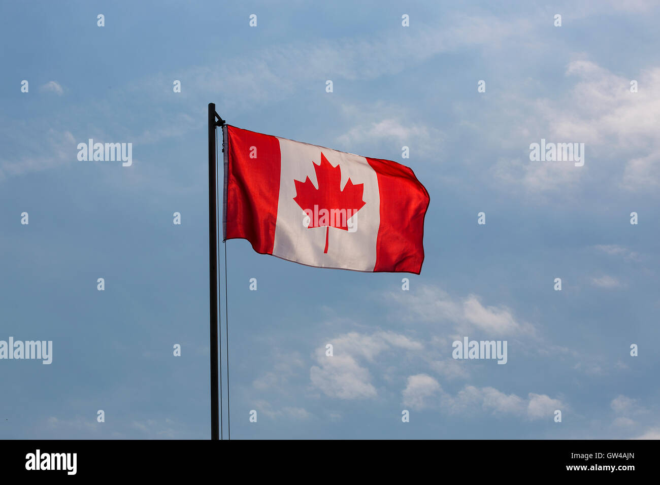 National flag of Canada on a flagpole in front of blue sky Stock Photo ...
