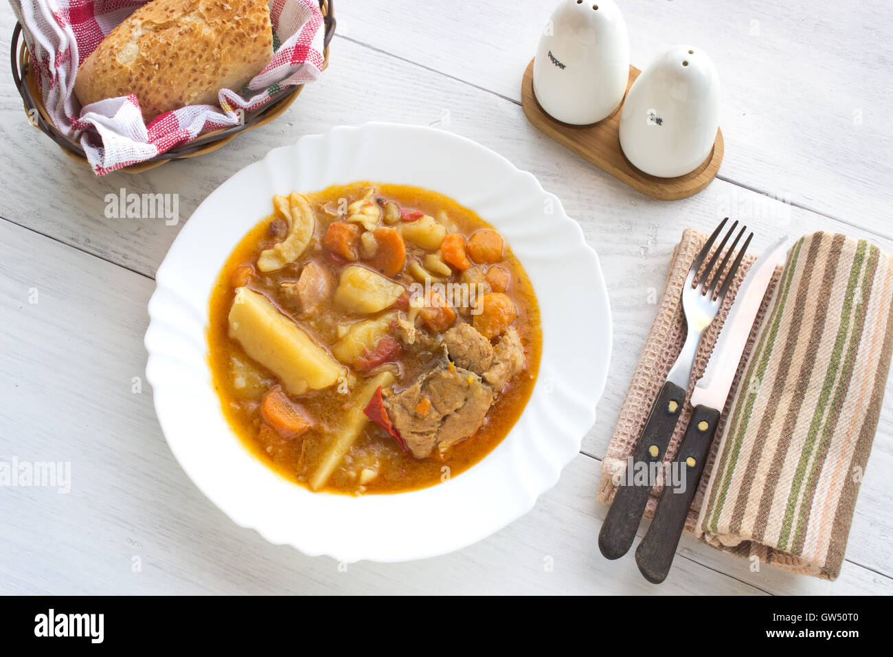 Chicken stew with potatoes in plate on white table Stock Photo - Alamy
