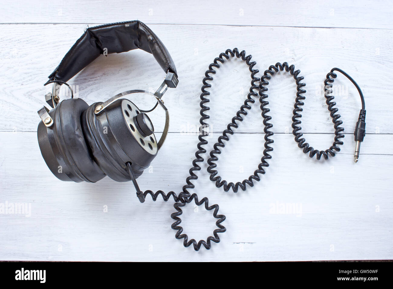 Pair of old sound headphones on white wooden background Stock Photo - Alamy
