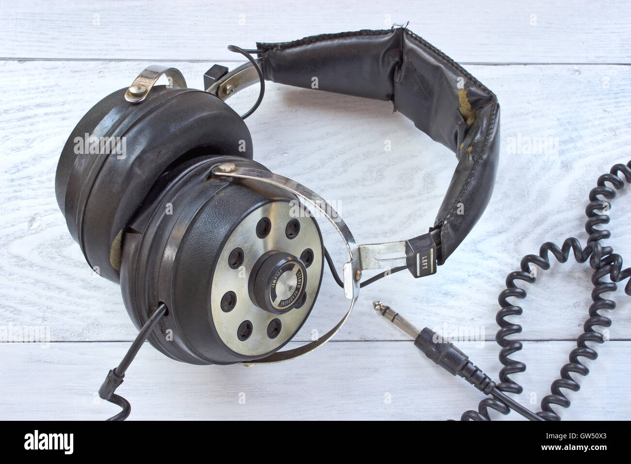 Old stereo headphones on white wooden background Stock Photo - Alamy