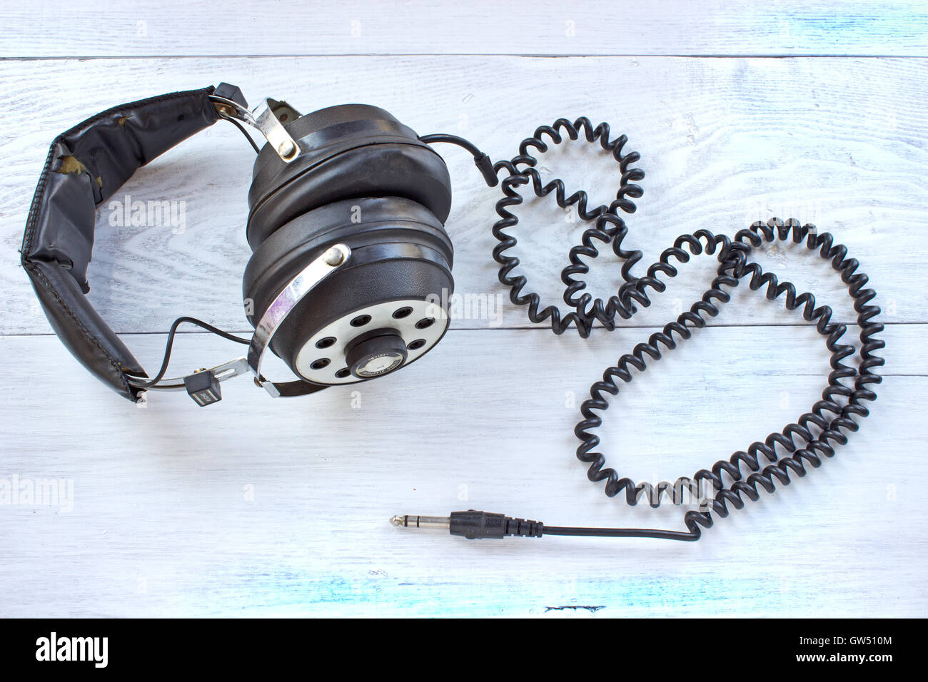 Old stereo headphones on white wooden background Stock Photo - Alamy