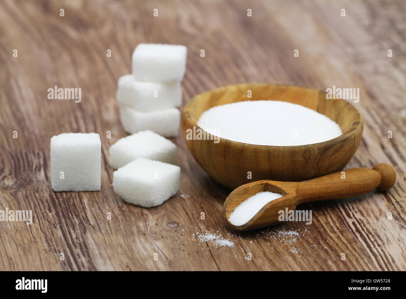 Stack of sugar cubes and salt in wooden bowl Stock Photo - Alamy