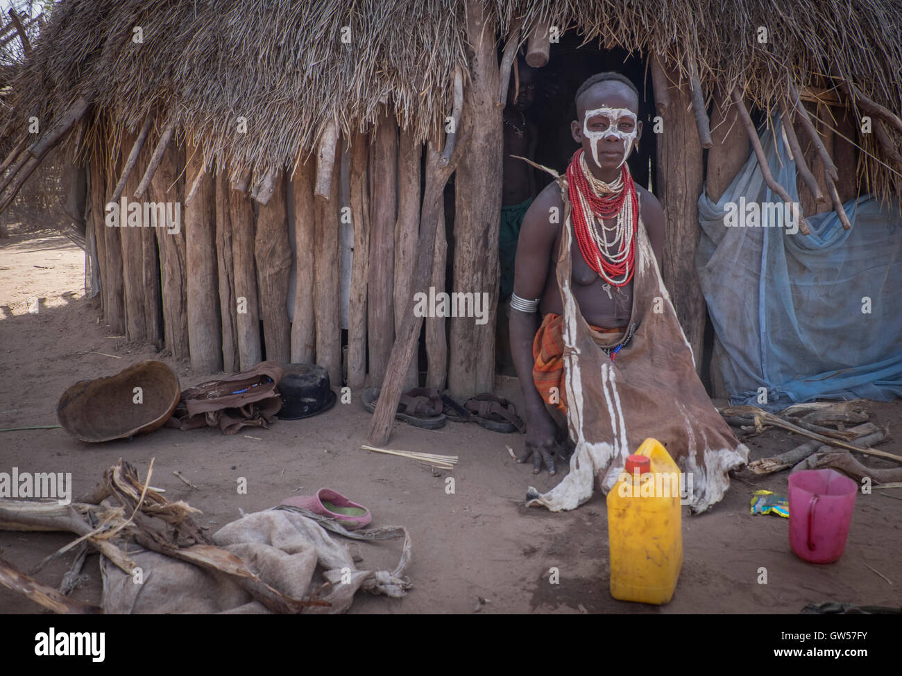 Woman Of The Karo Tribe In The Omo Valley Of Ethiopia Sits In Front Of Her Thatched Hut With Her