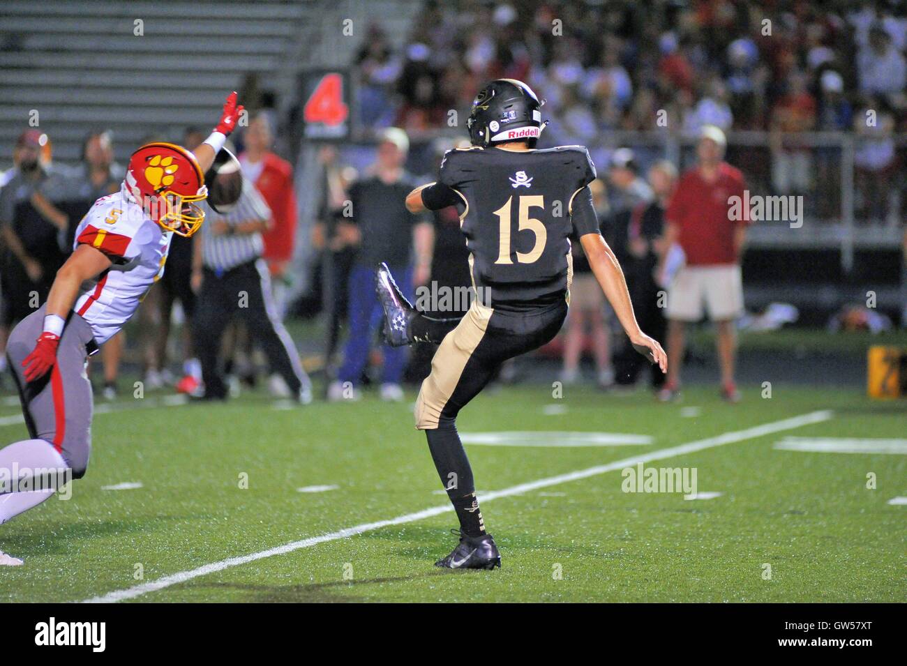 Punter nearly has his kick blocked by a charging opponent during a high ...