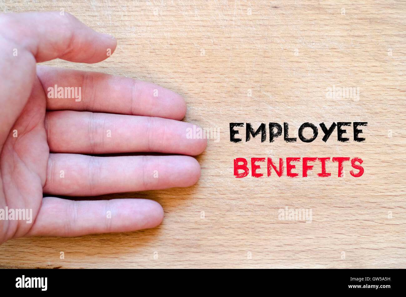 Human hand over wooden background and employee benefits text concept ...