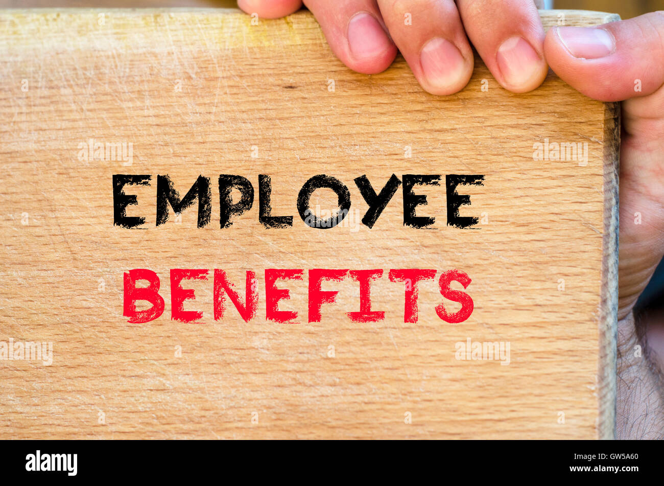 Human hand over wooden background and employee benefits text concept ...