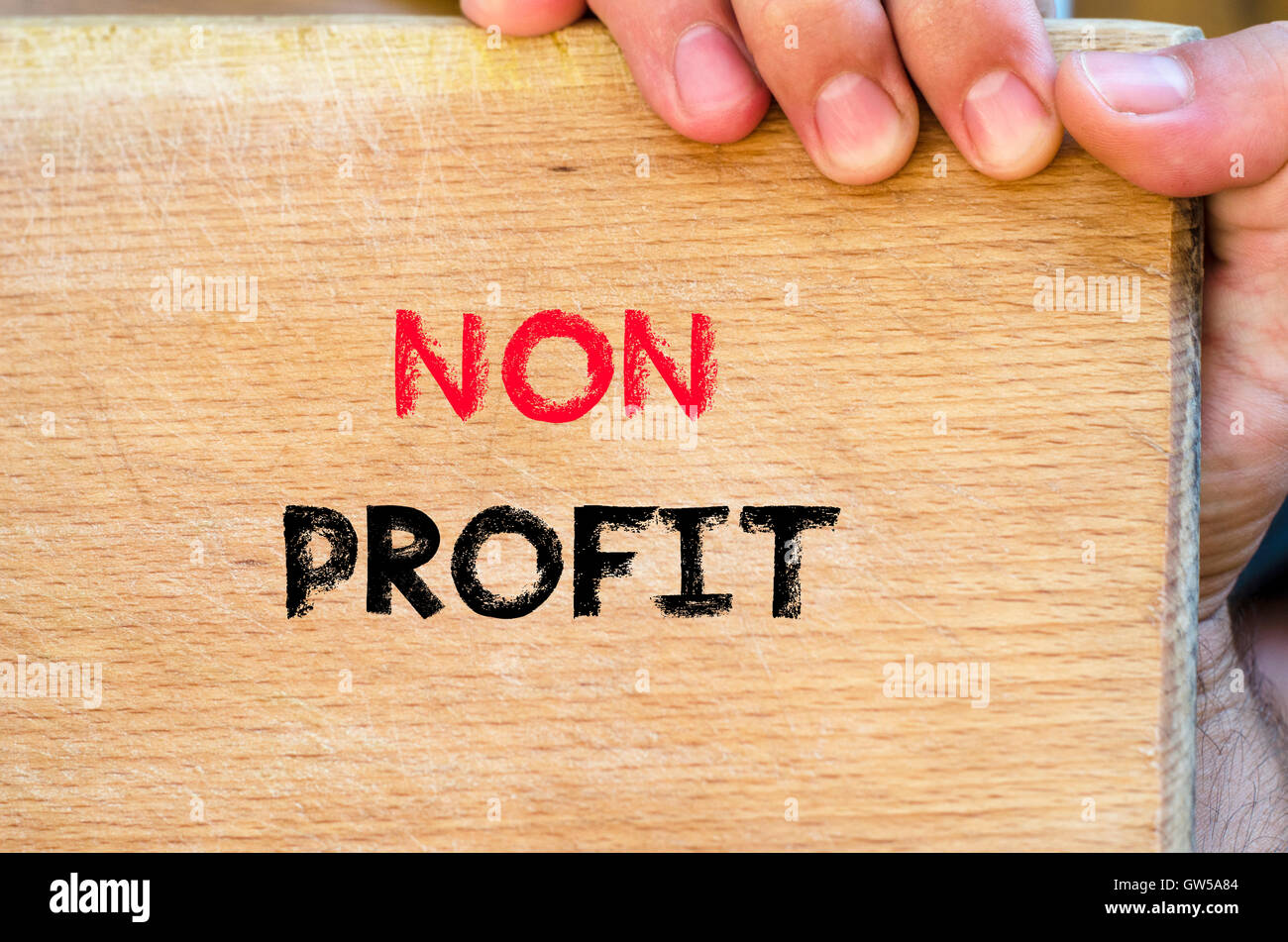 Human hand over wooden background and non profit text concept Stock ...